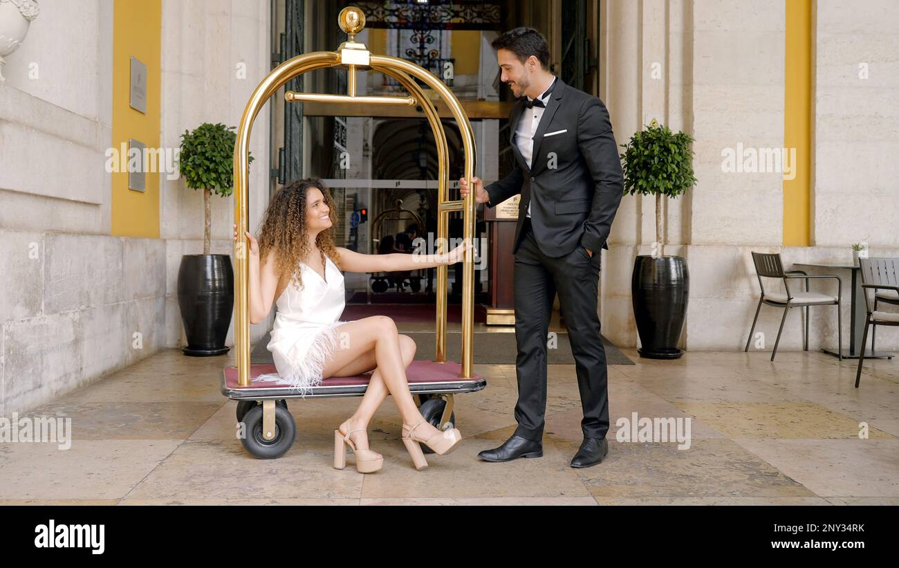 Elegant couple at entrance to hotel. Action. Elegant woman sits on ...