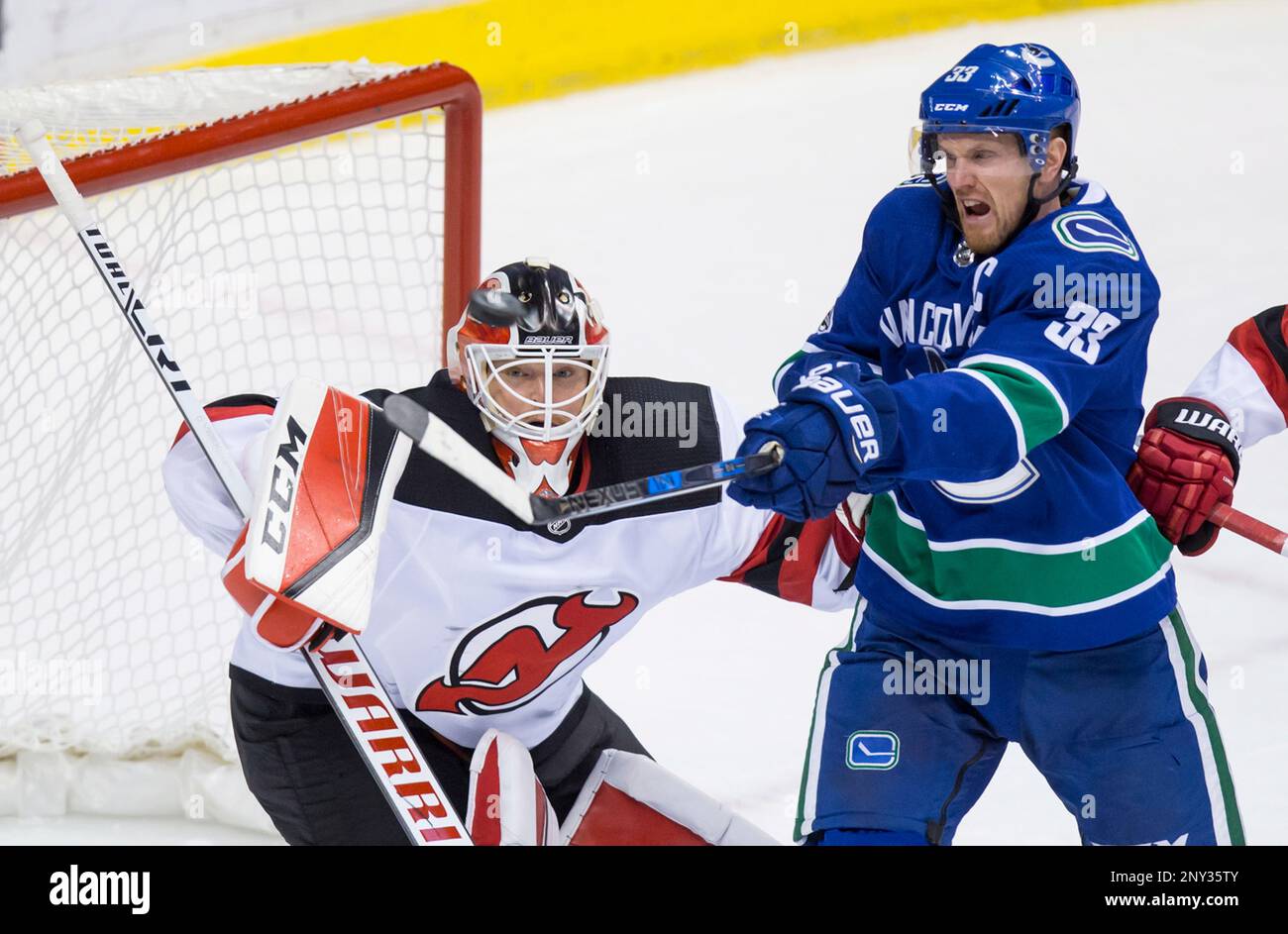 Vancouver Canucks' Henrik Sedin, right, of Sweden, attempts to get his ...