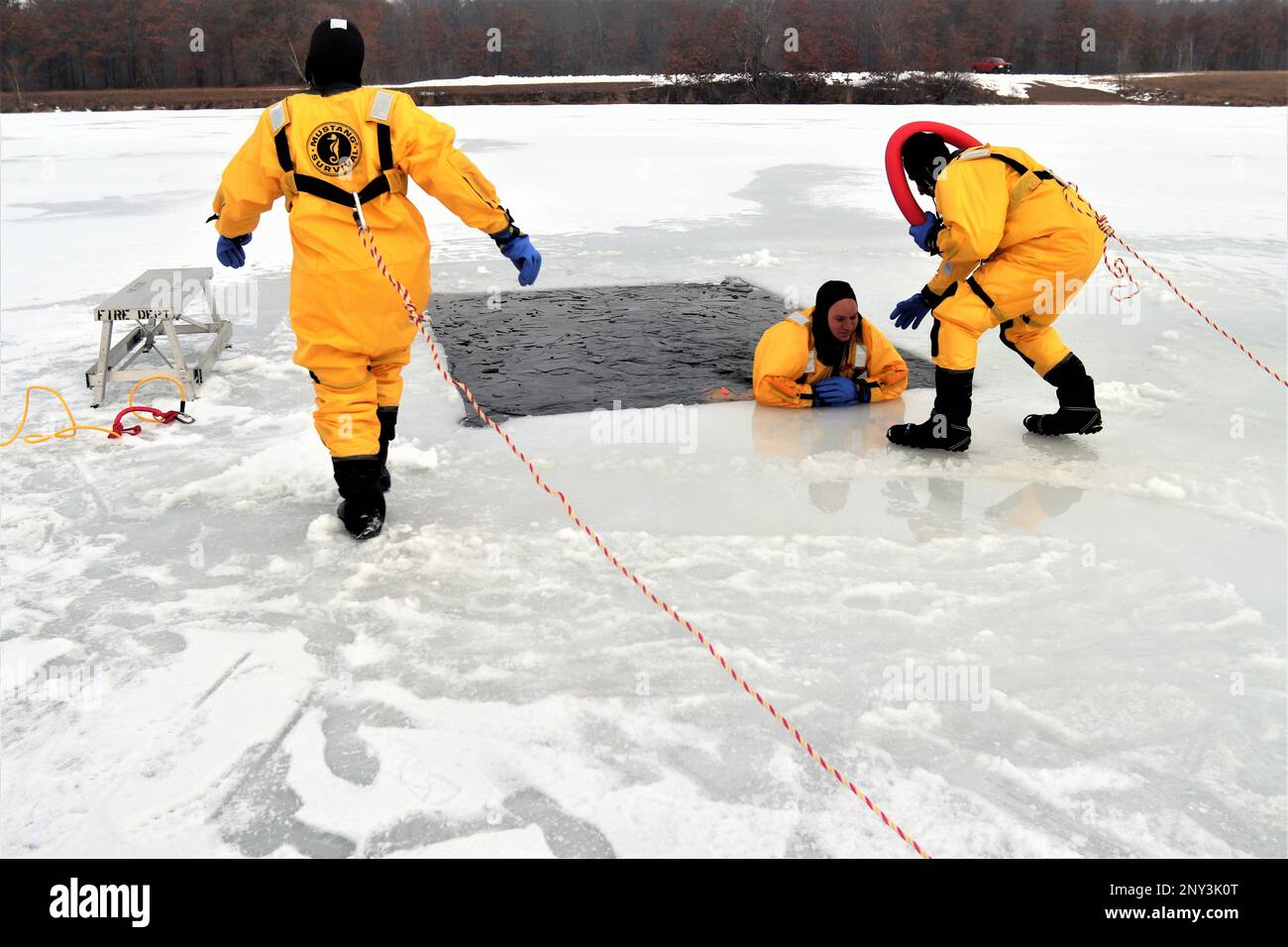 Firefighters wearing cold-water immersion protective suits hold surface ...