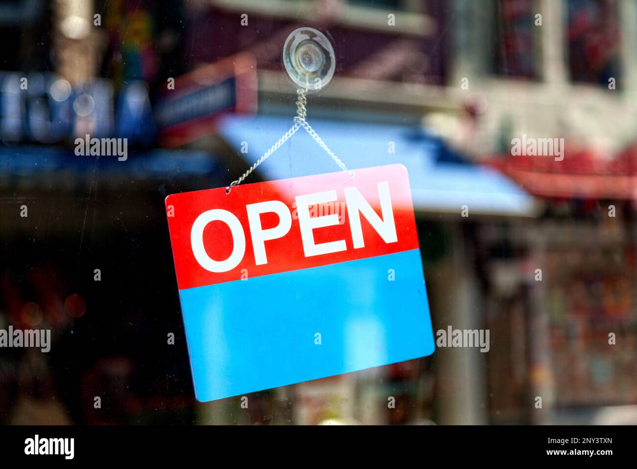Red and blue sign in the window of a shop saying in "Open Stock Photo ...