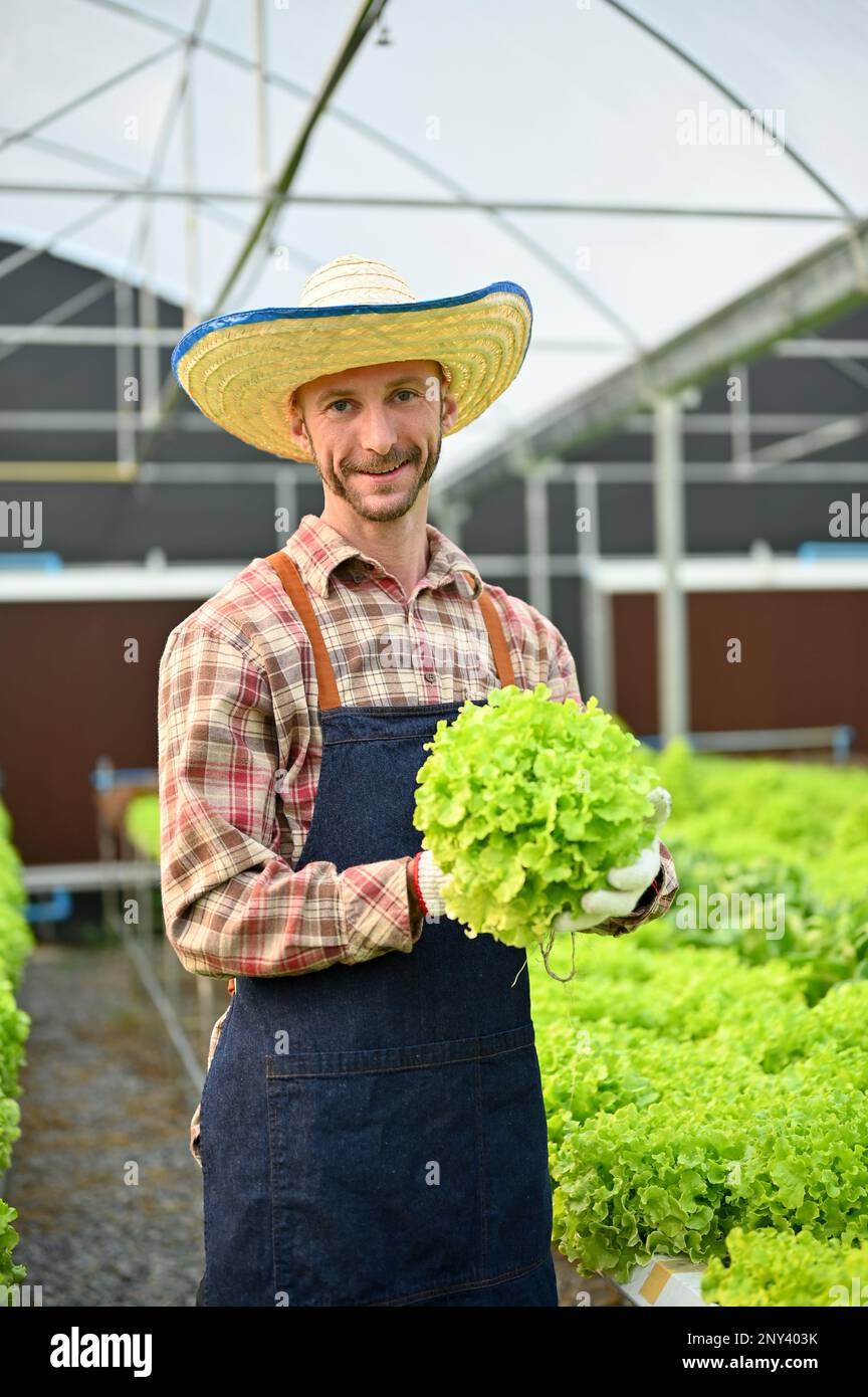 Handsome smiling Caucasian male farm owner or farmer with a straw hat ...