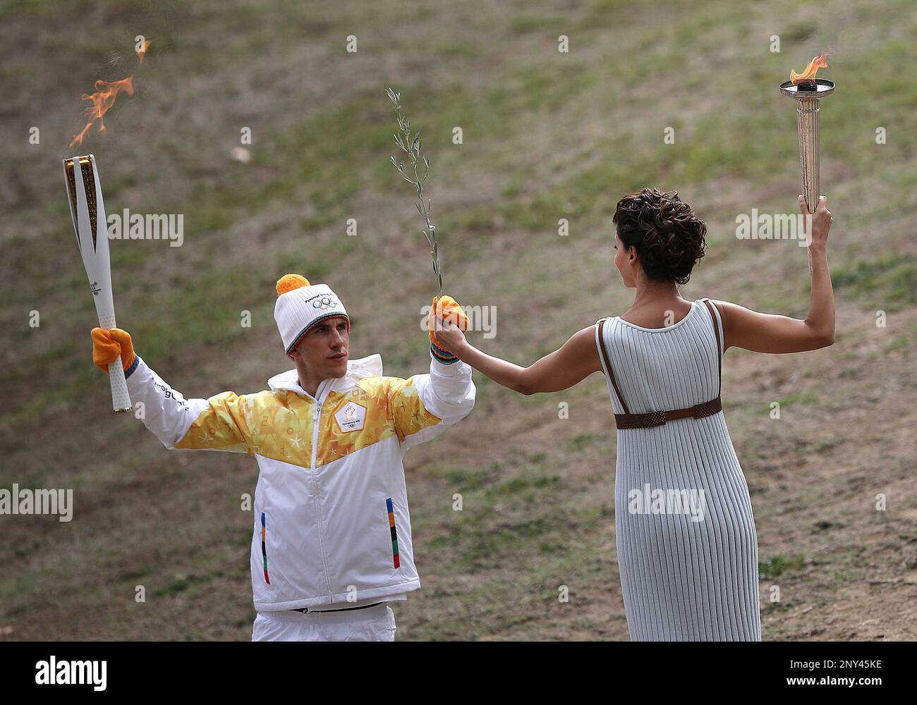 Actress Katerina Lehou as high priestess, right, gives an olive branch ...