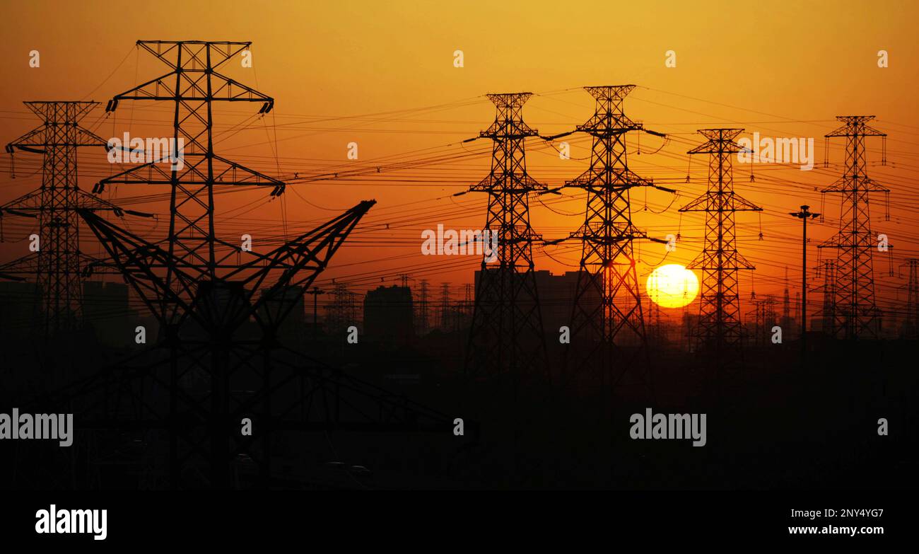A photo shows power transmission lines in the morning sun in Beijing ...