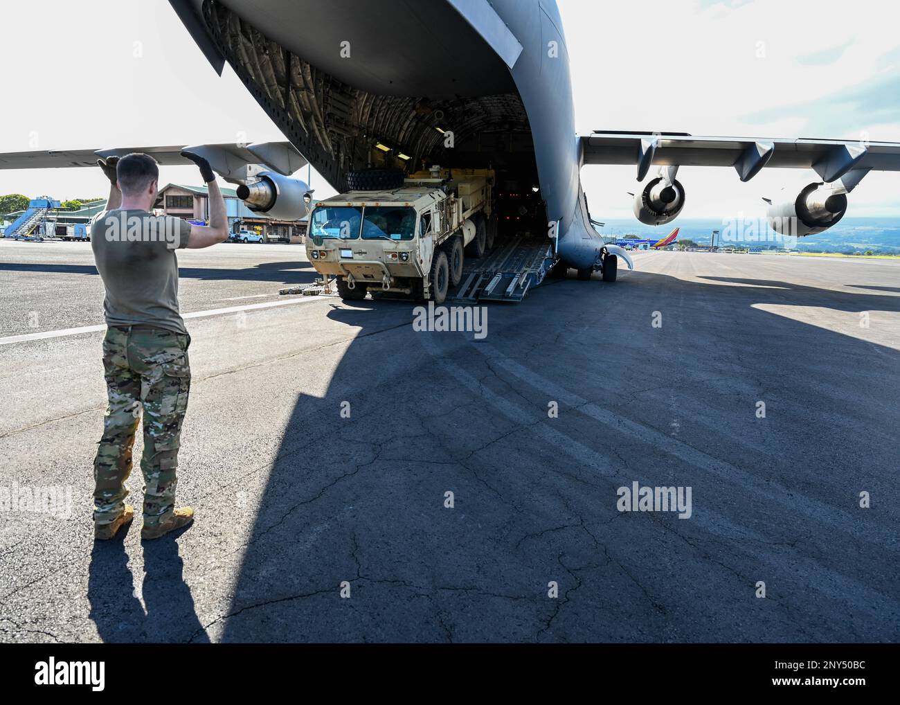 Senior Airman Andrew Girard, 535th Airlift Squadron C-17 Globemaster III loadmaster, directs a ...