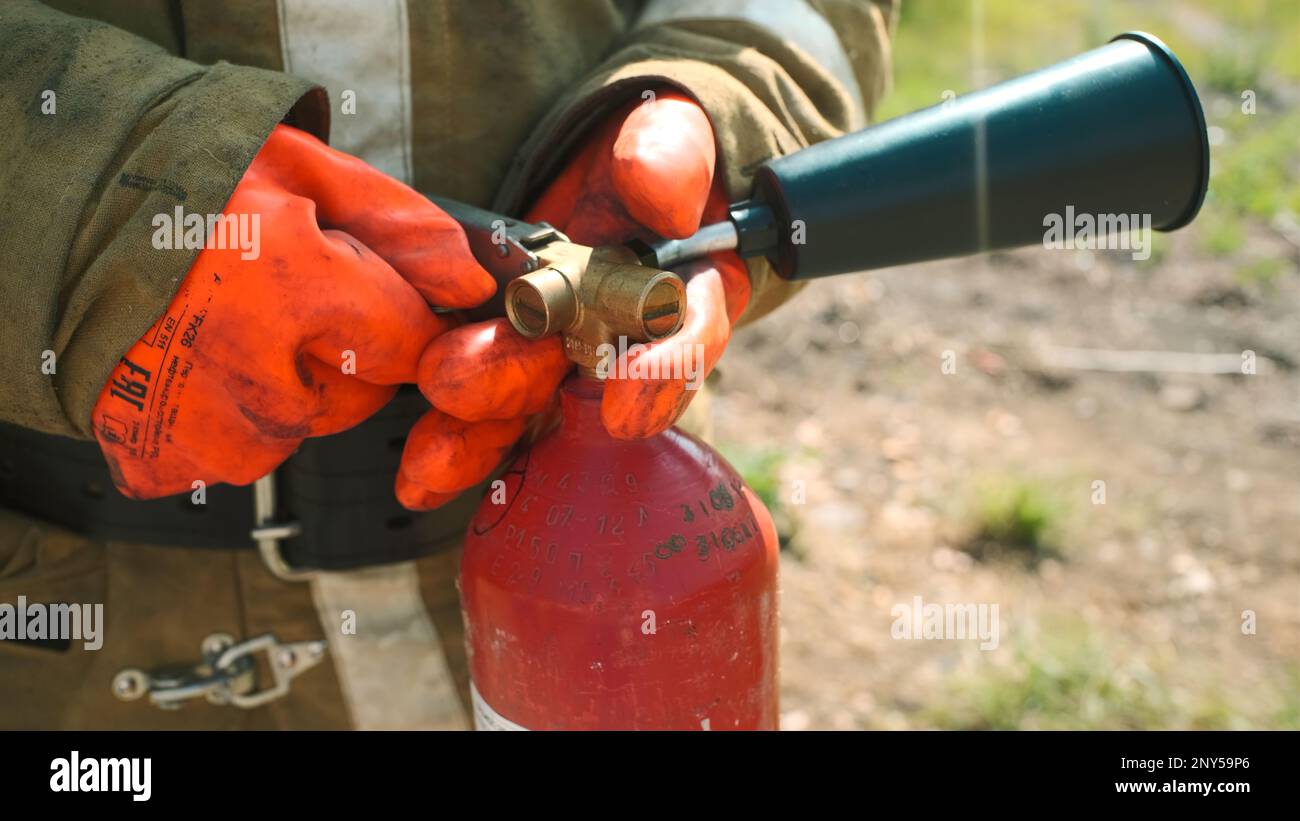 Close-up of firefighter with fire extinguisher. Clip. Firefighter picks ...