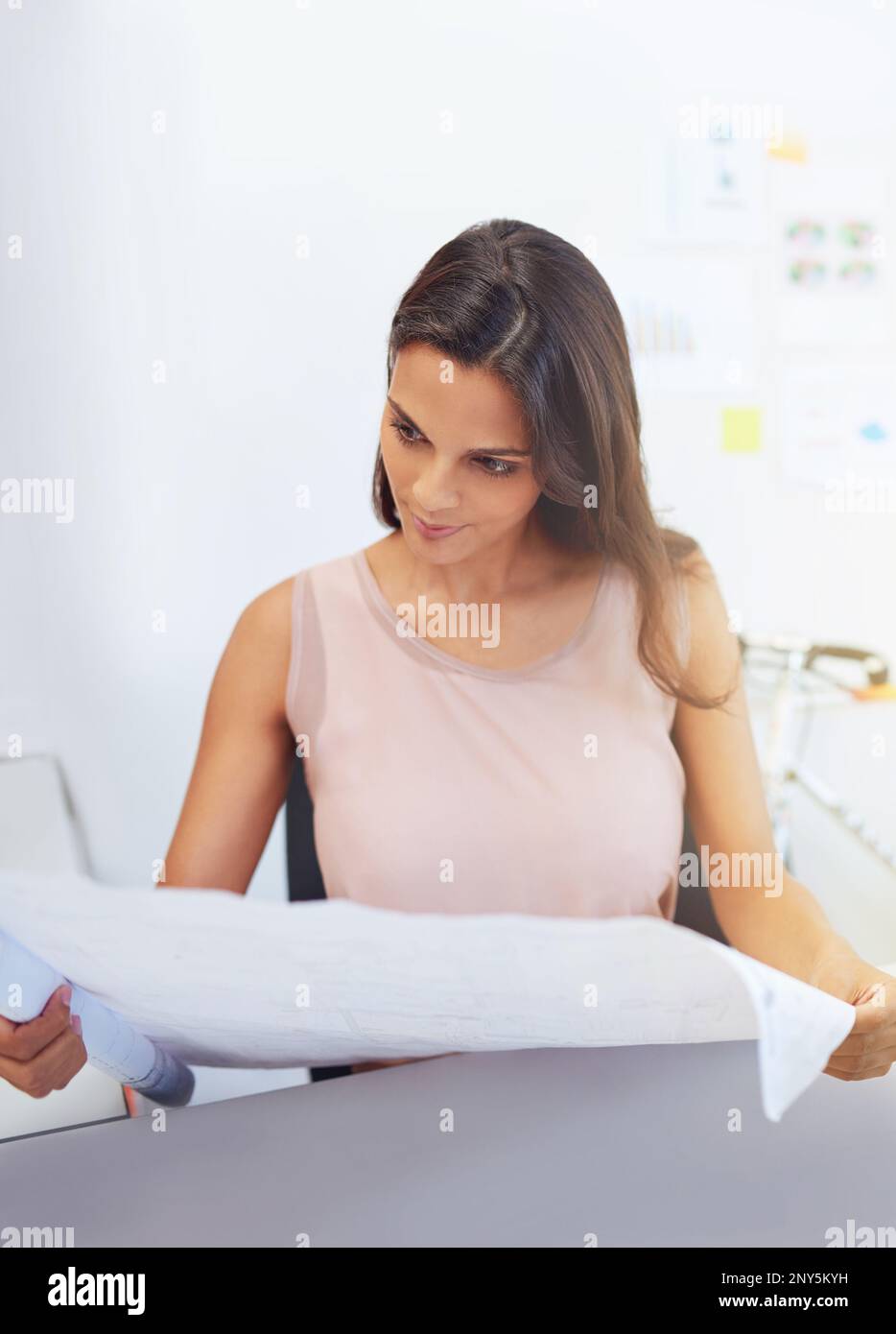 Taking a quick look over the plans. a young architect looking over some ...