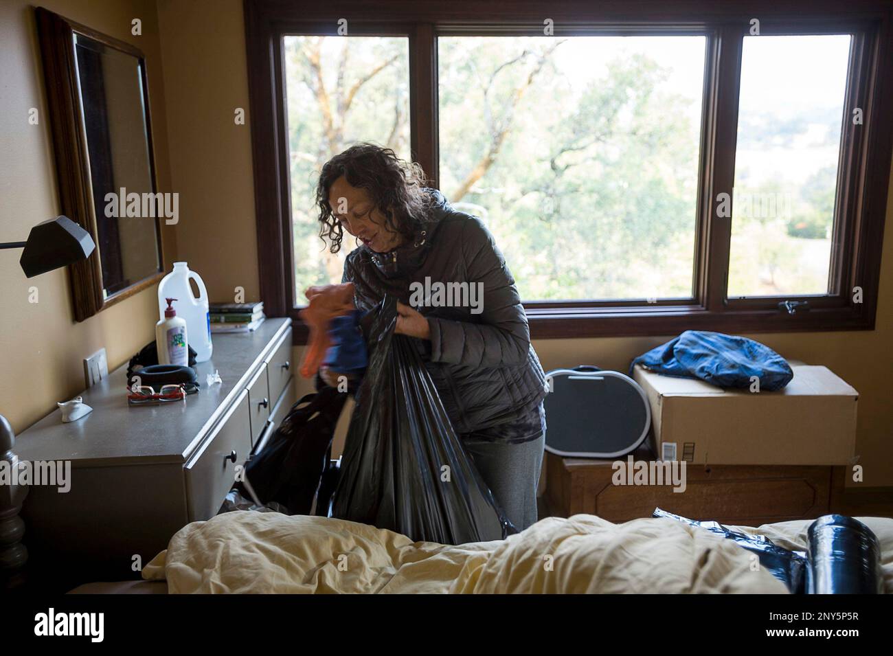 Alexandra Sagues, 67, packs her family's belongings with her husband ...