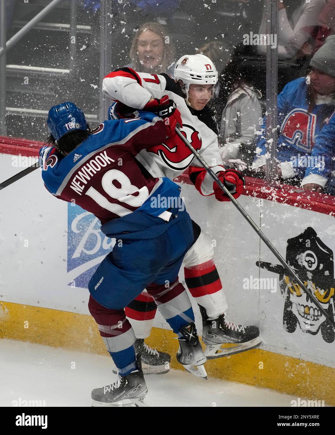 Colorado Avalanche center Alex Newhook, front, checks New Jersey Devils ...