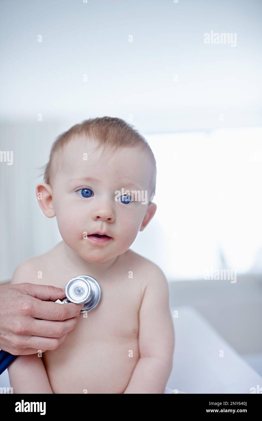 Making sure hes in good health. A baby boy getting examined by a doctor ...