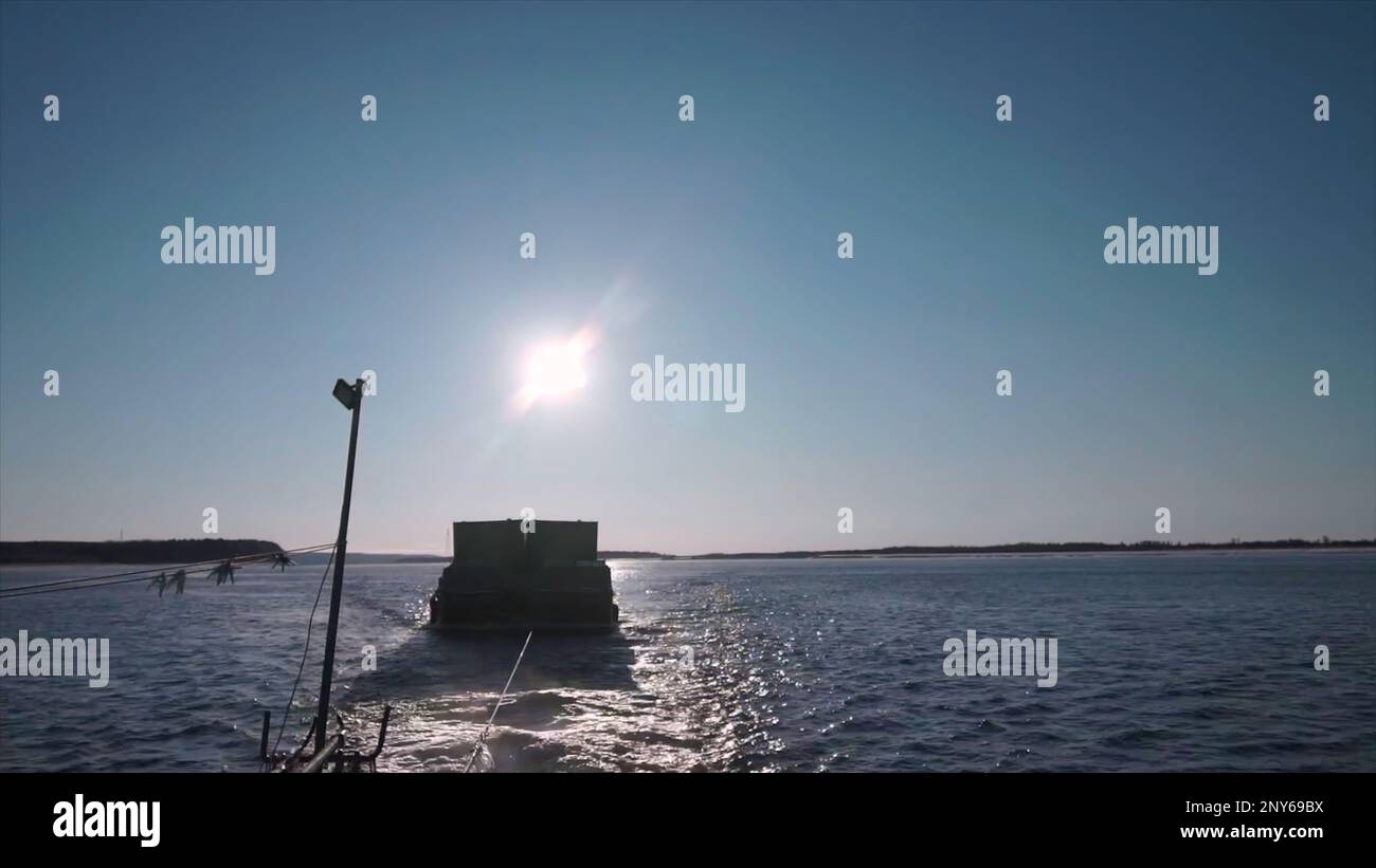 View of cargo floating behind boat on river. Clip. River cargo tug is ...