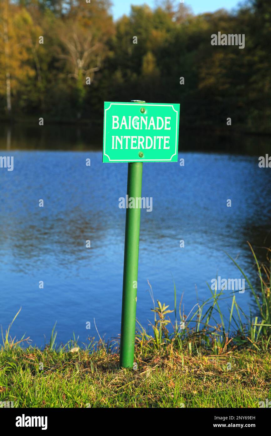 Sign by a lake saying in french "Baignade interdite", meaning "No ...