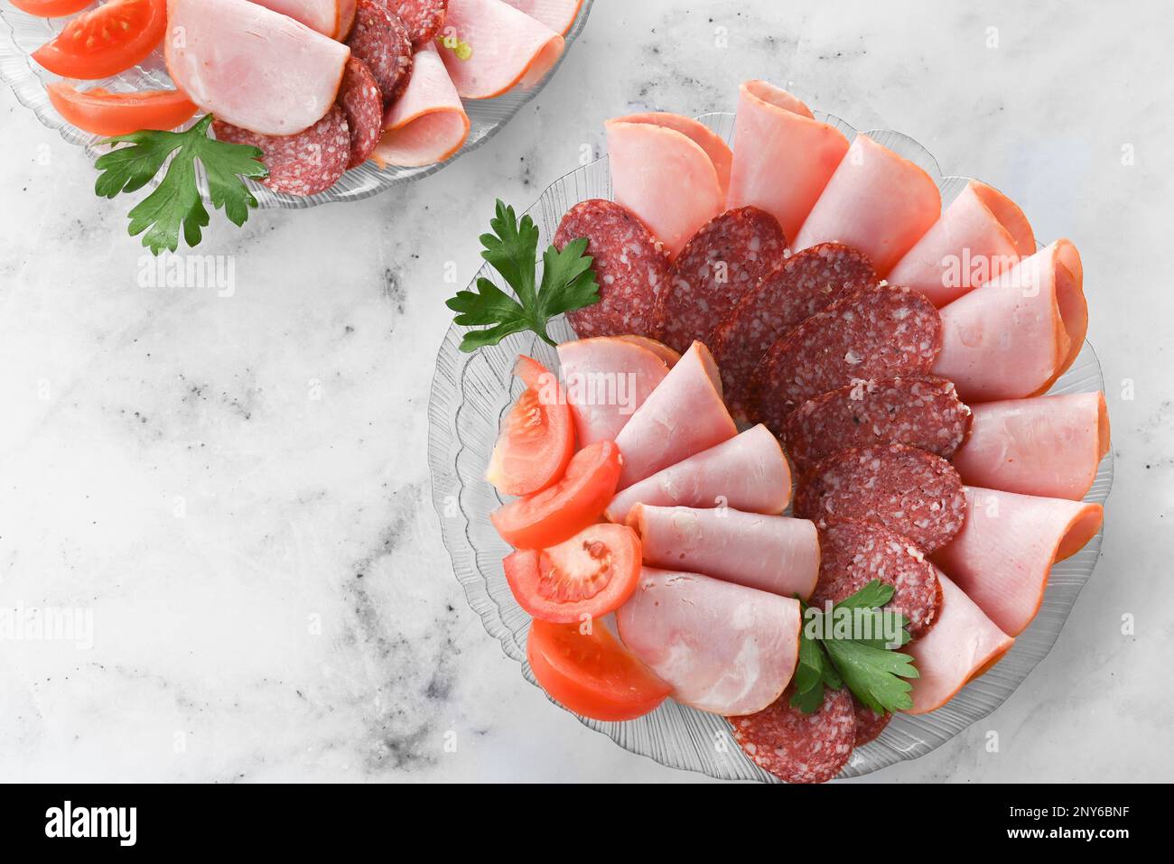 plate with an assortment of boiled, smoked sausage on bright table ...