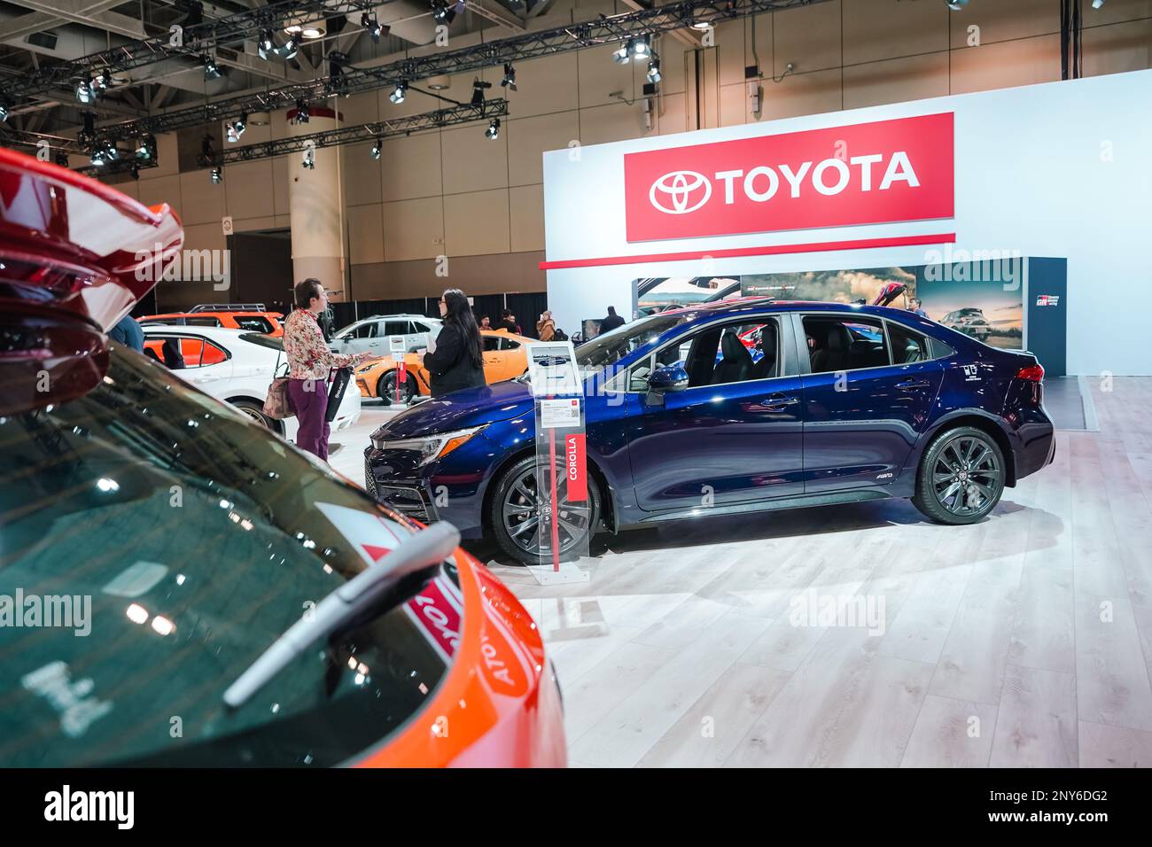 Toyota car booth showcasing 2023 car models with customers chatting on ...