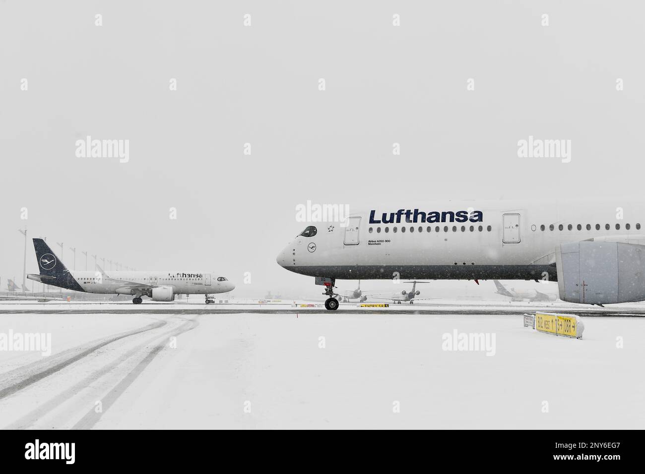 Aircraft taxiing on taxiway in winter snow flurry for de-icing and take ...