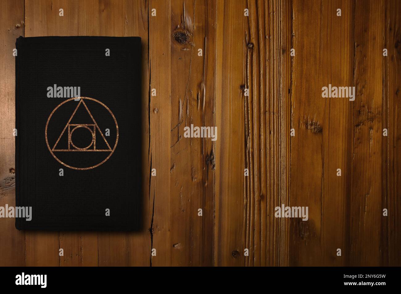 Close-up on an alchemy book with a gilded Philosopher's stone symbol in ...