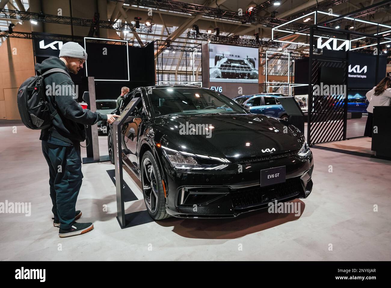Young man checking out a black car at a car show Stock Photo - Alamy