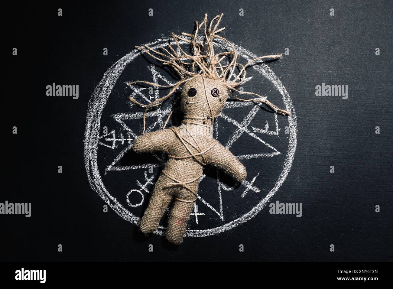Female voodoo doll and runes on black background, top view Stock Photo ...
