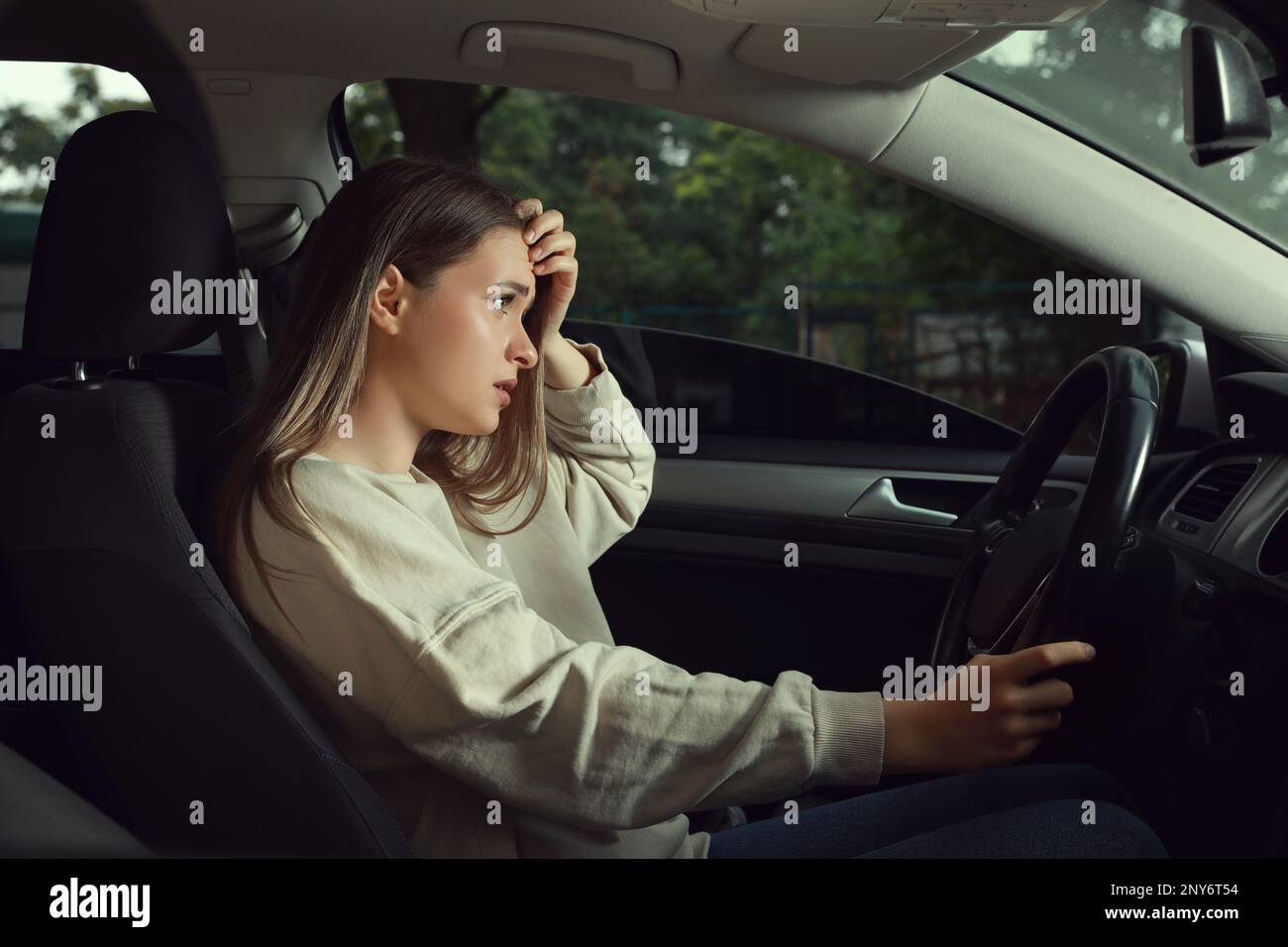 Stressed young woman in driver's seat of modern car Stock Photo - Alamy