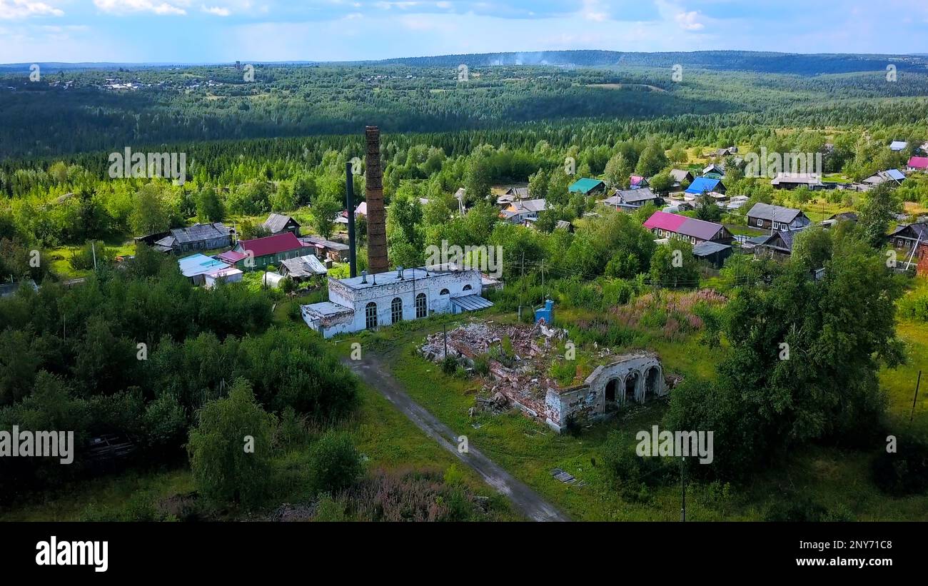 Aerial view of a village located by the river shore. Clip. Flying above ...
