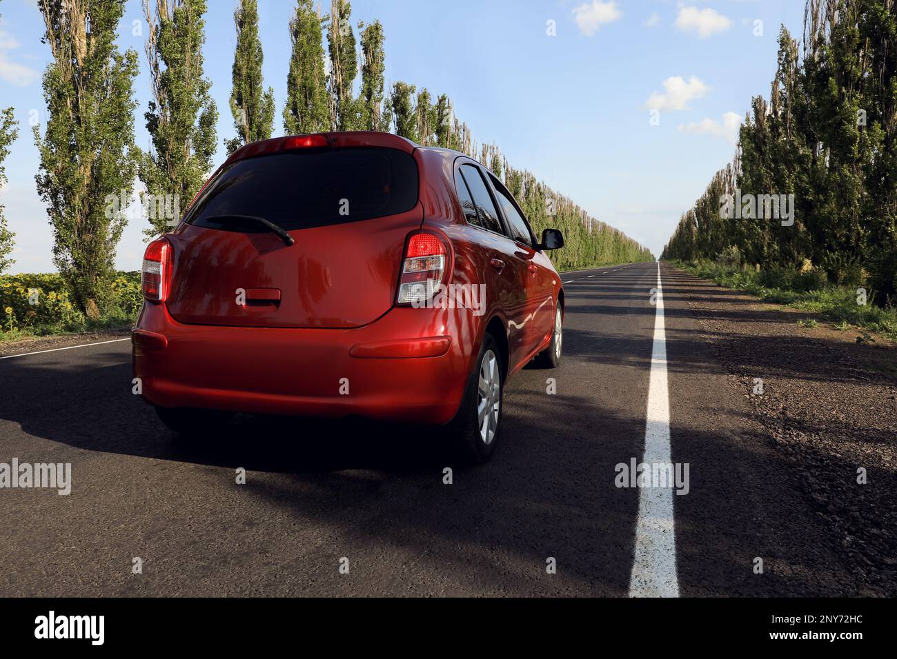 Red car on asphalt road in countryside Stock Photo - Alamy