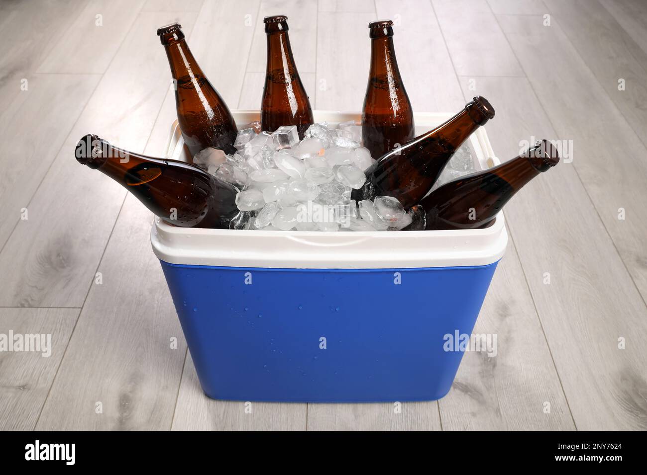 Blue plastic cool box with ice cubes and beer on wooden floor Stock ...