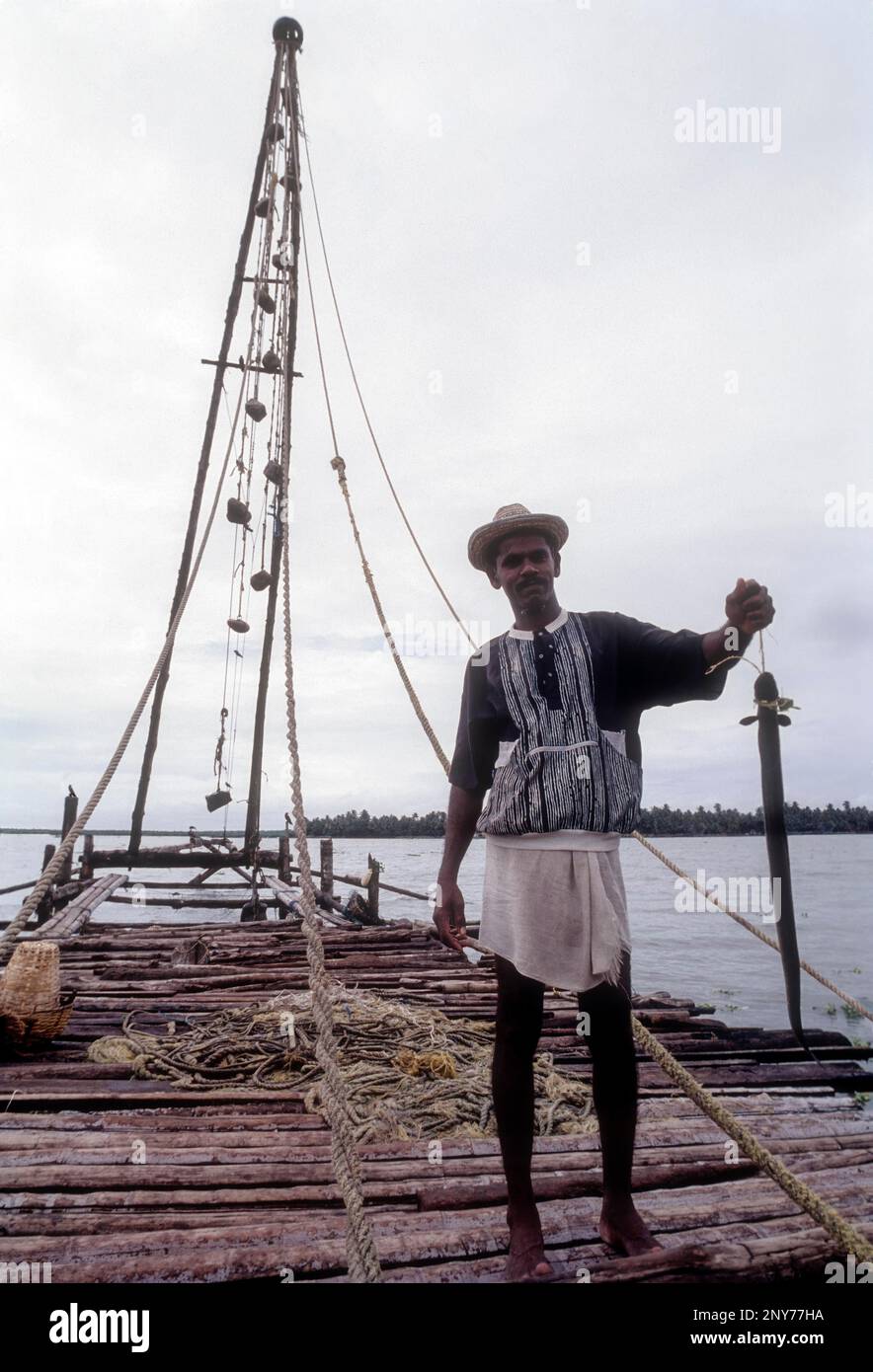 Fisher man with his catch eel fish standing above the Chinese Fishing ...