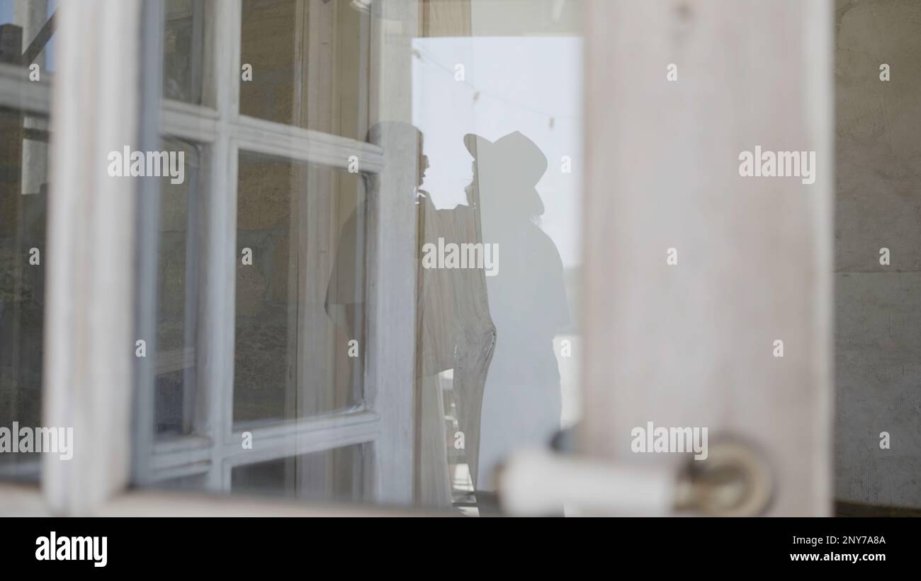 View through the window with translucent curtains to the people in a ...