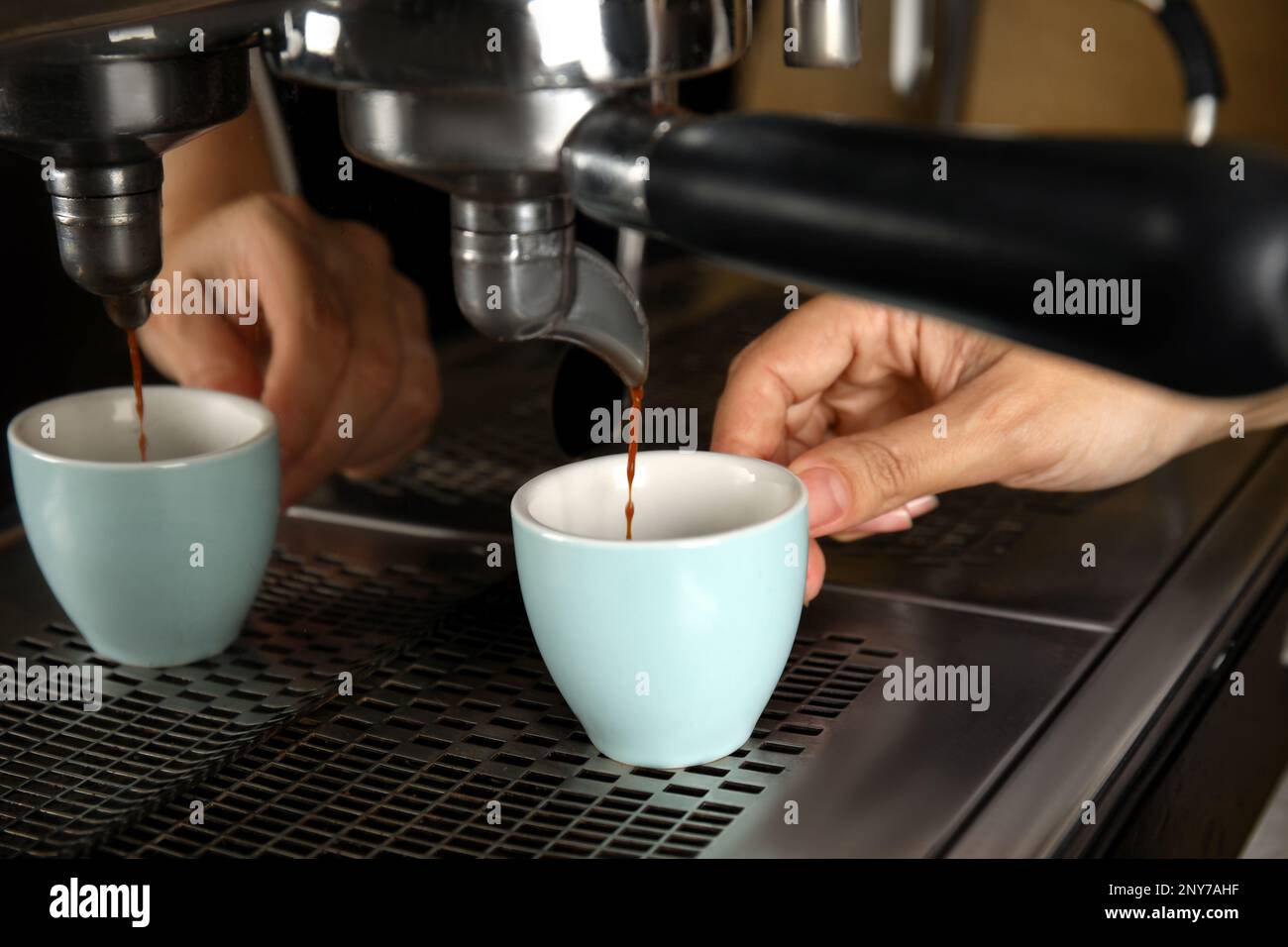 Barista making espresso using professional coffee machine, closeup ...