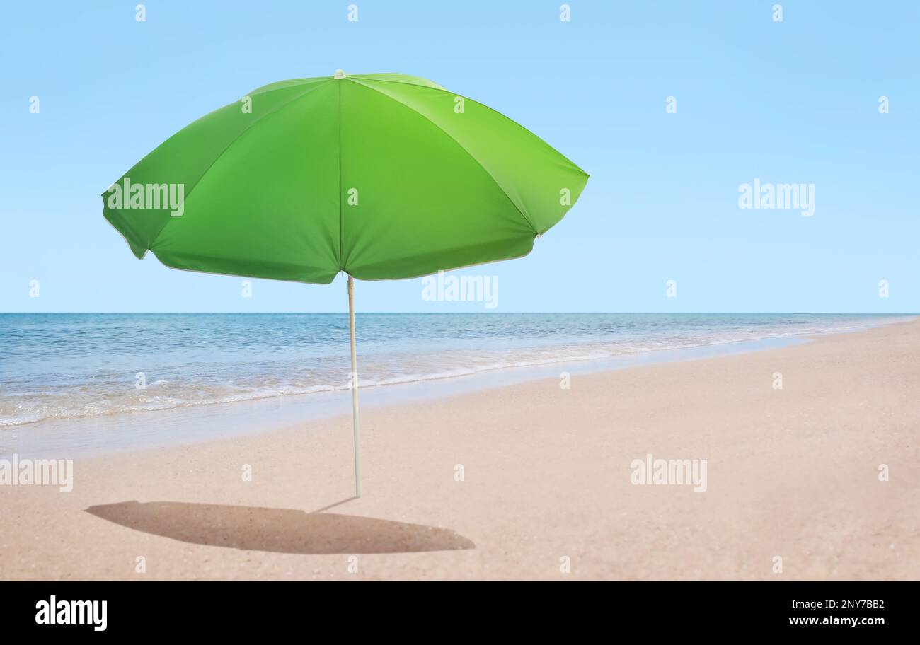 Open big beach umbrella on sandy coast Stock Photo - Alamy