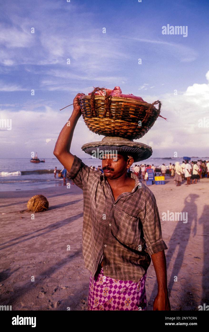 A Fisherman carrying basket full of fish on head, Kerala, South India ...