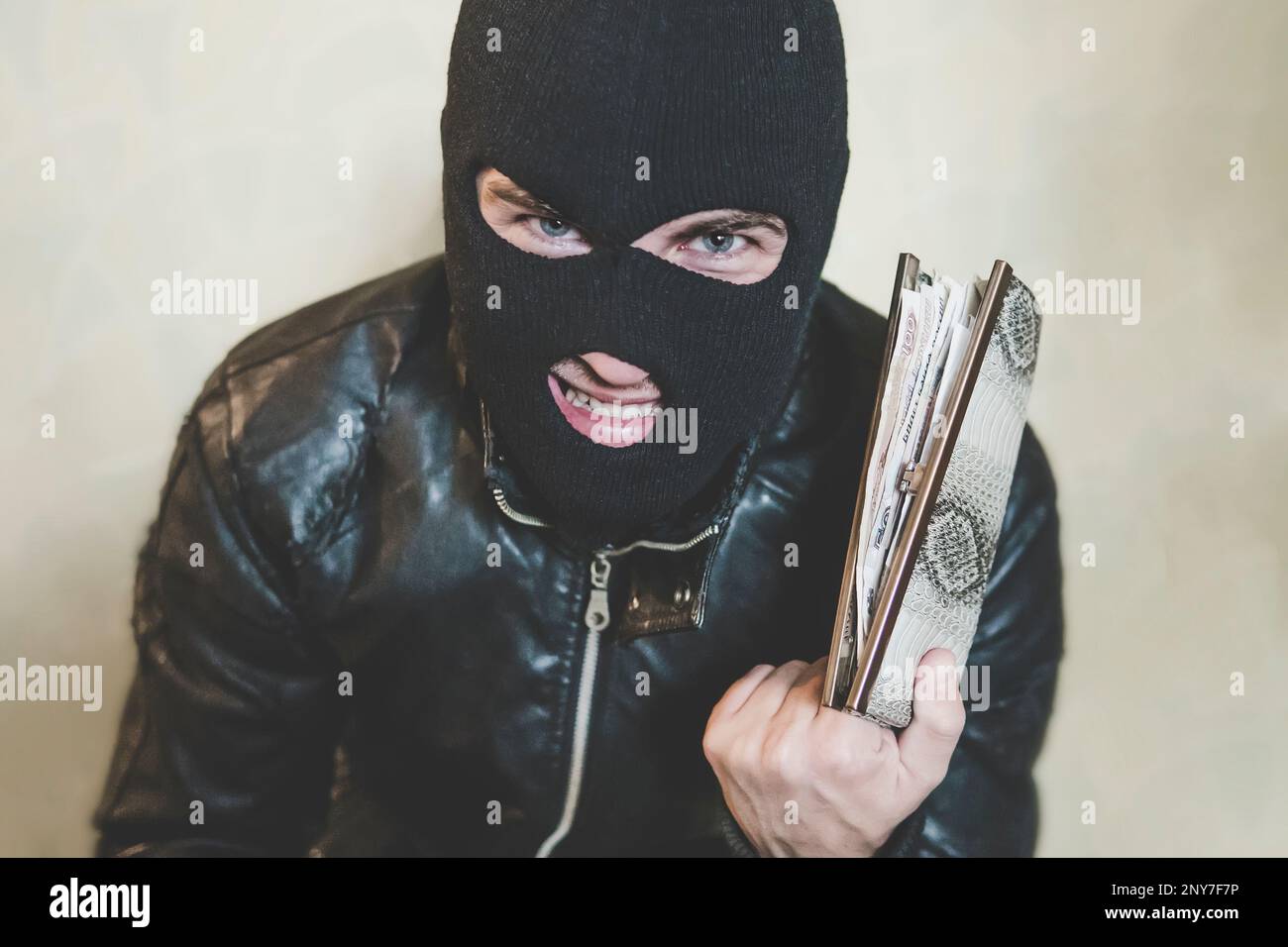 Half shot of gloating pickpocket in black mask looking at the viewer ...