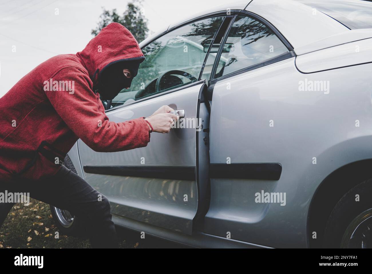 Young thief managed to break the car door using sceleton key. Evil-doer ...