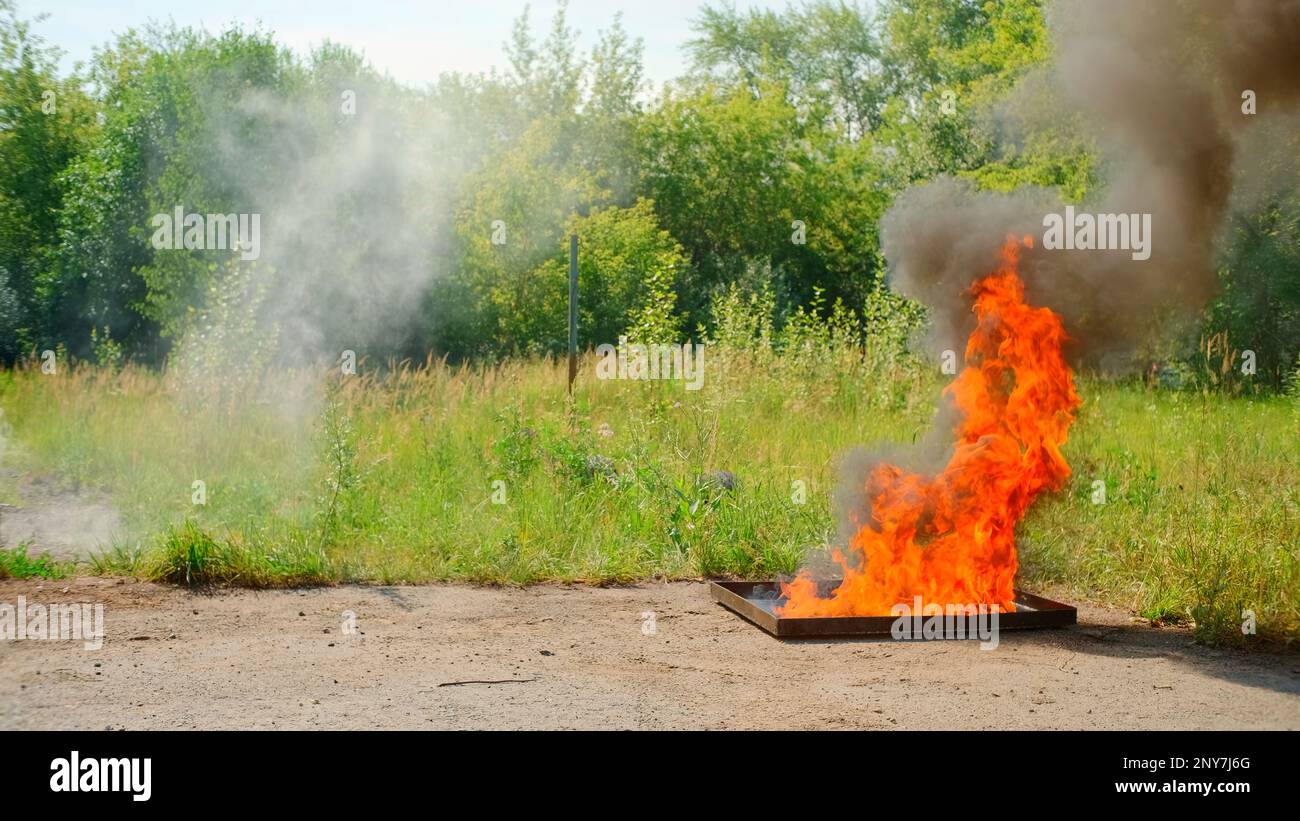 Firefighter using fire extinguisher on flames from the burning ...