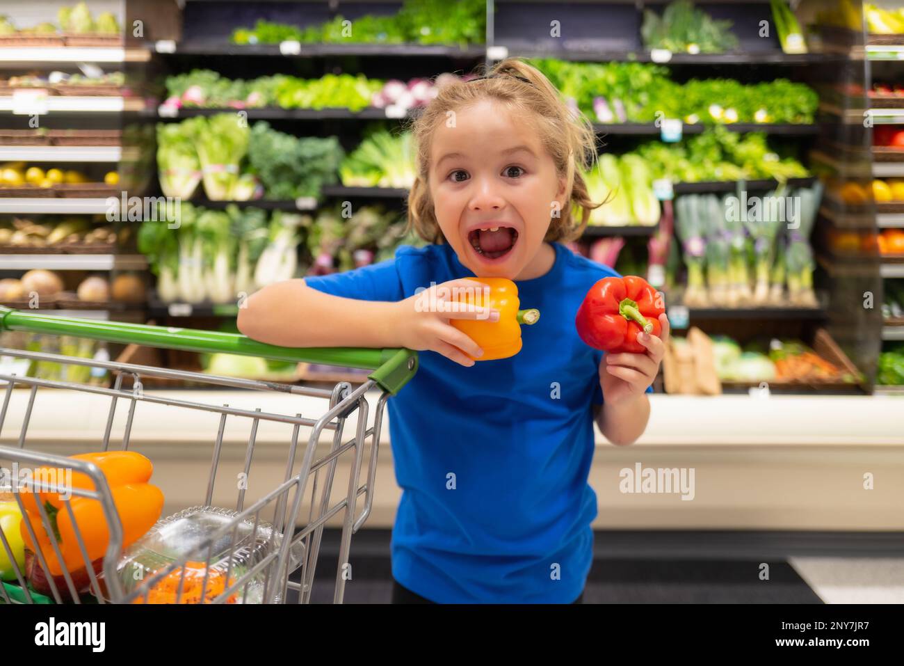 Kid with vegetables and peppers at grocery store. Healthy food for kids ...