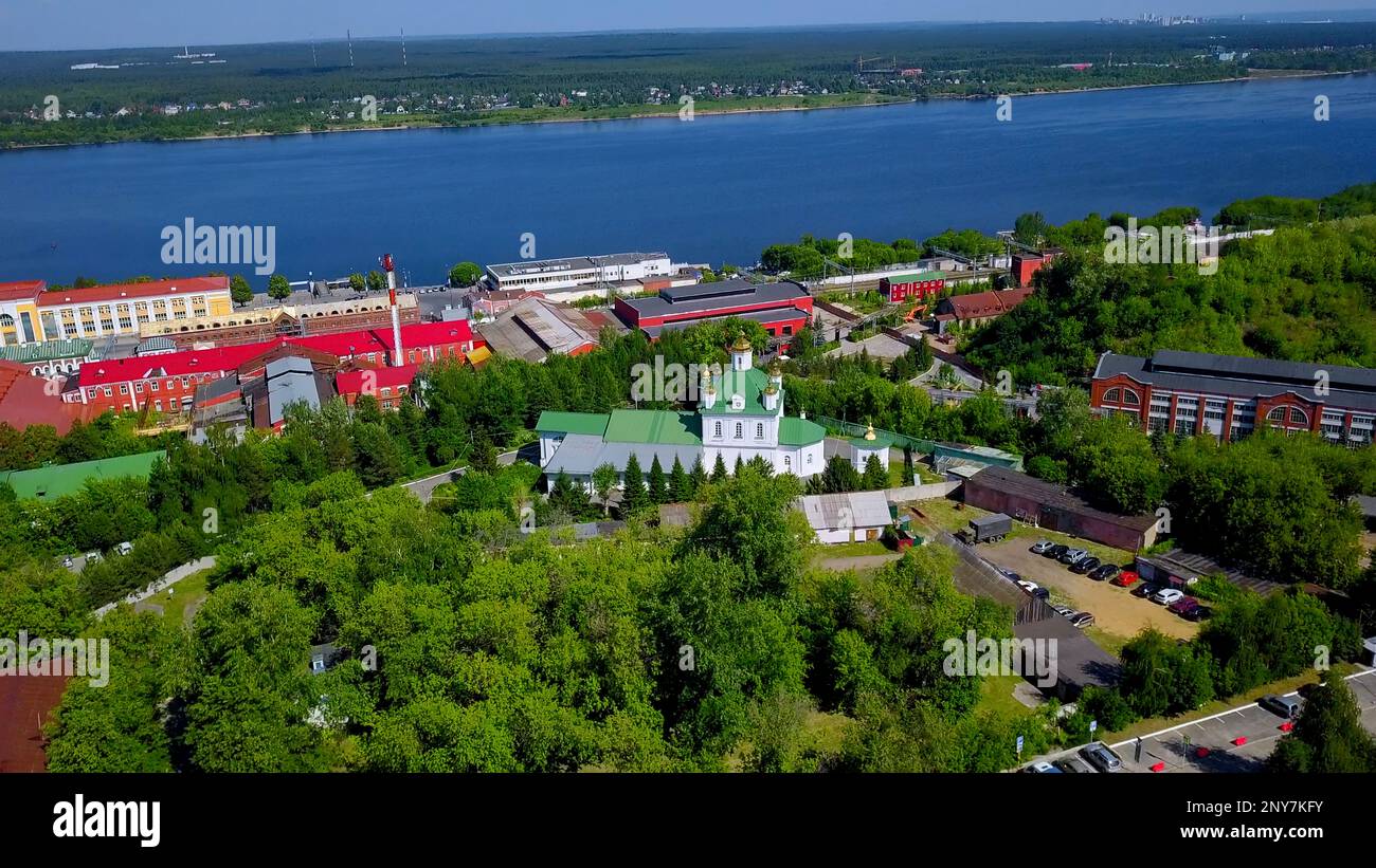 Aerial view of a village located by the river shore. Clip. Flying above ...