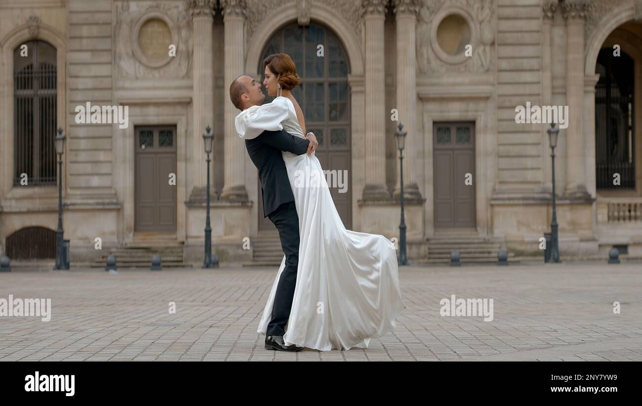Happy just married groom carry on his hands the bridge in Paris, France ...