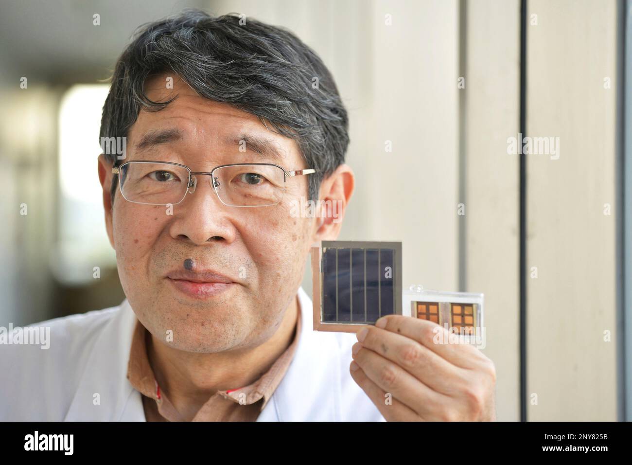 Professor Tsutomu Miyasaka holds Perovskite solar cells during an interview at Toin University ...