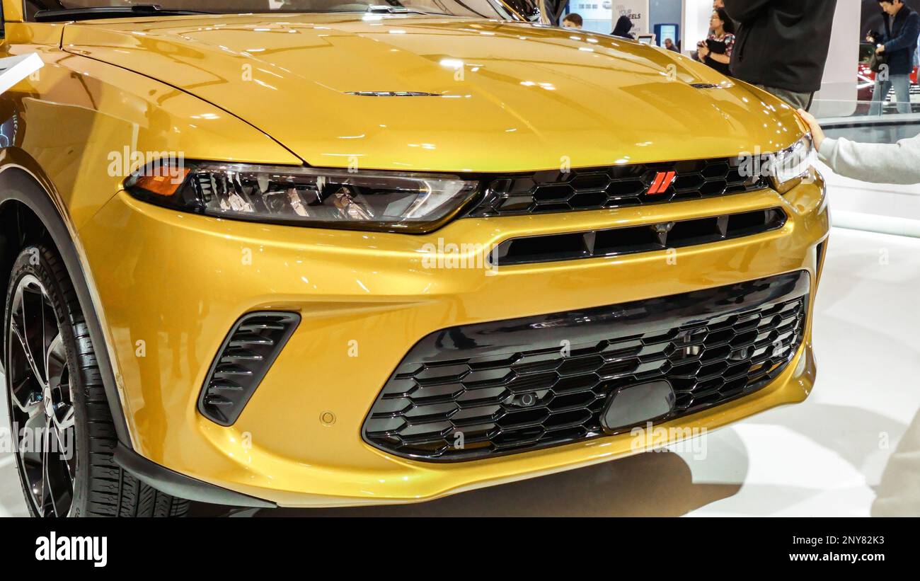 Close up view of yellow dodge GT car on display. Crowds looking at new ...