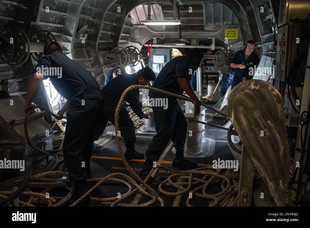 SINGAPORE (February 1, 2023) Sailors pull in lines in the forecastle ...