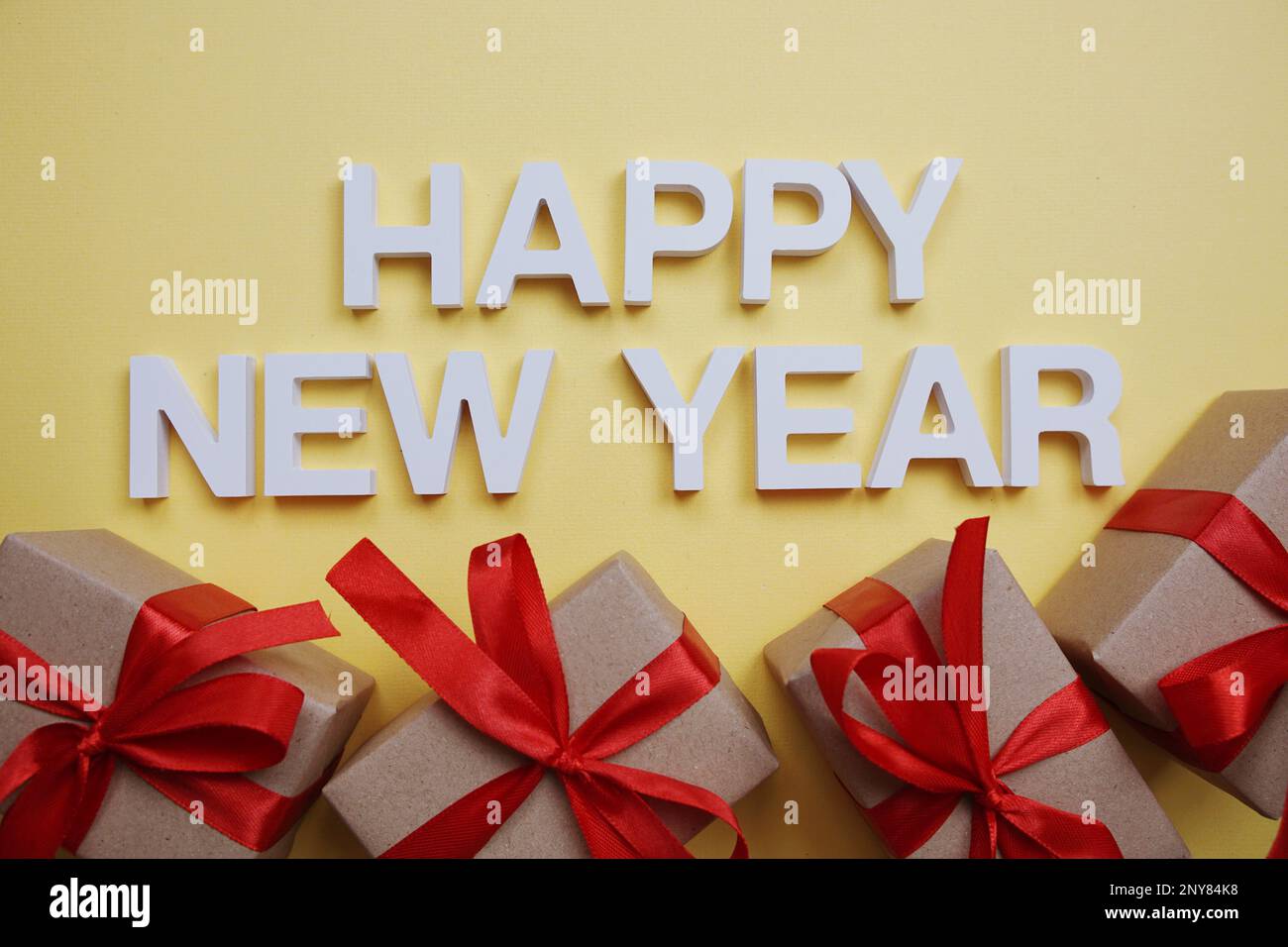 Happy New Year alphabet letters with gift boxes on yellow background ...