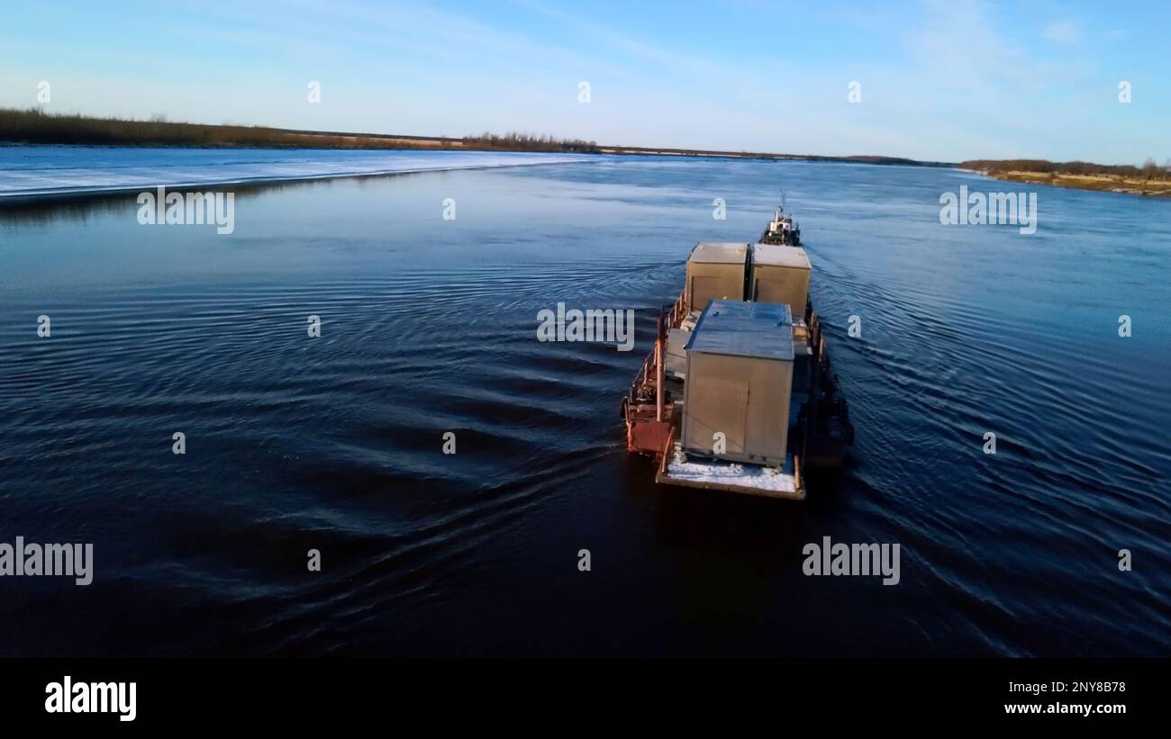 Industrial background with a barge and a river with snowy shore. Clip ...