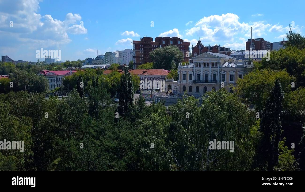 Green summer forest with city buildings behind. Clip. Blue cloudy sky ...