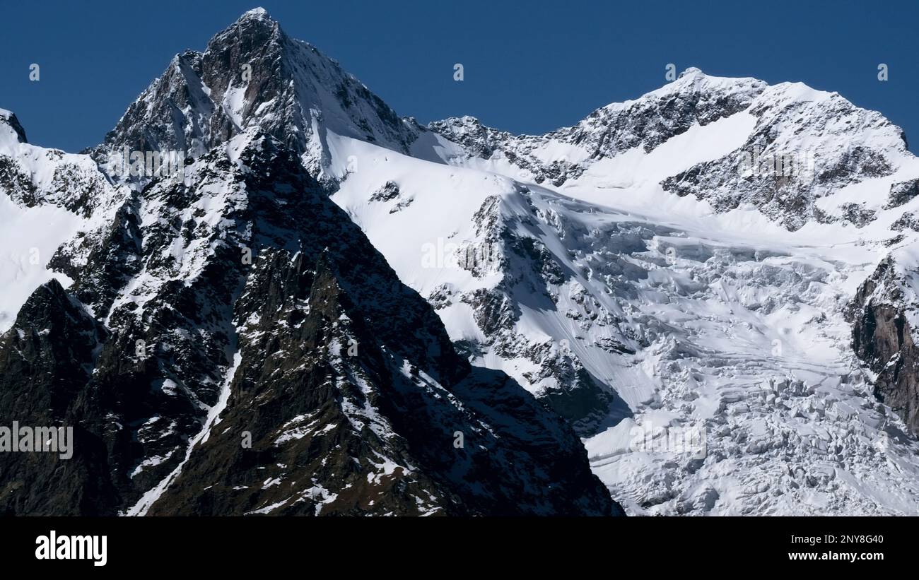 Aerial view of epic winter snow covered mountains on a blue background ...