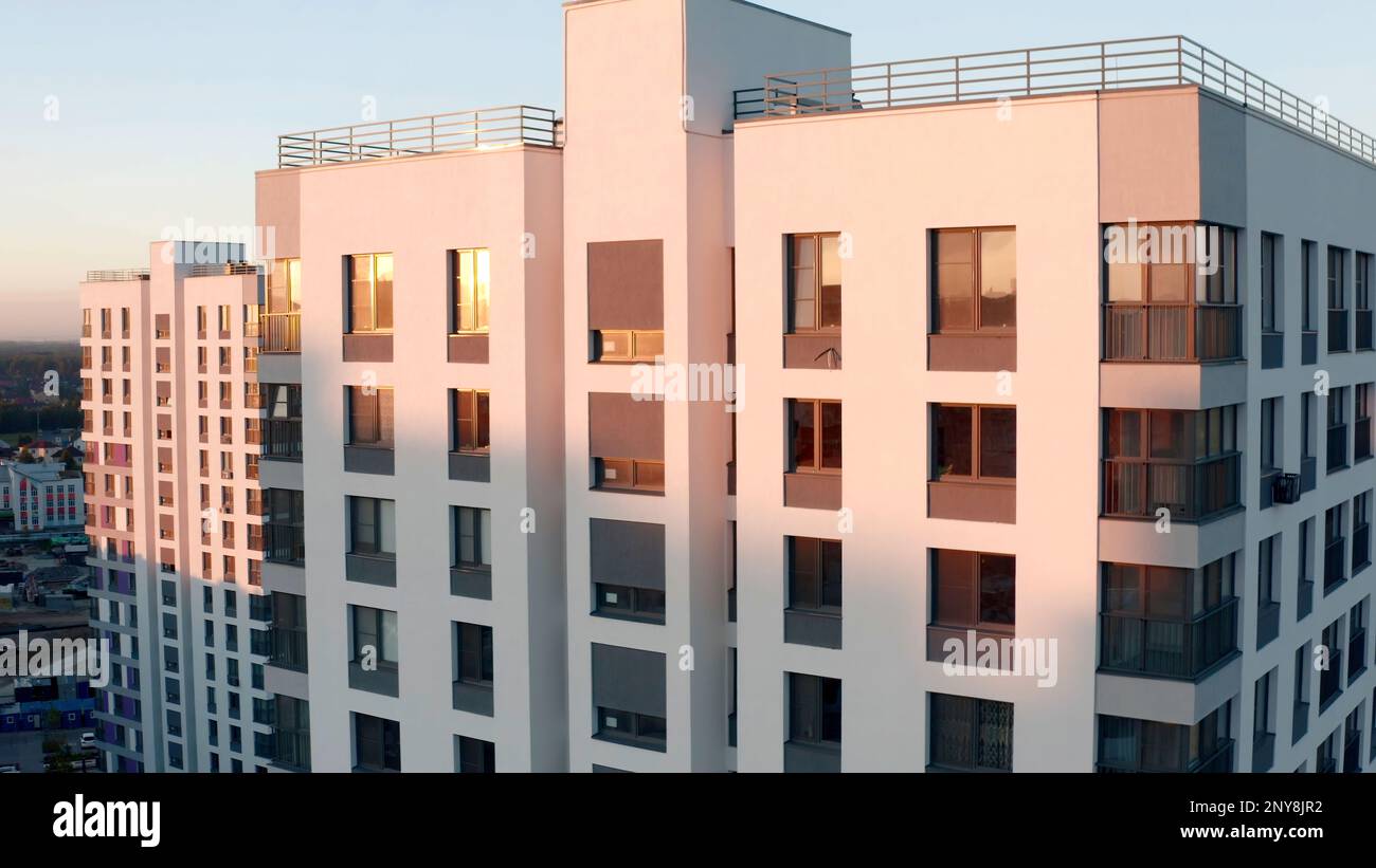 Flying around the multi storey residential building on a cloudy blue ...
