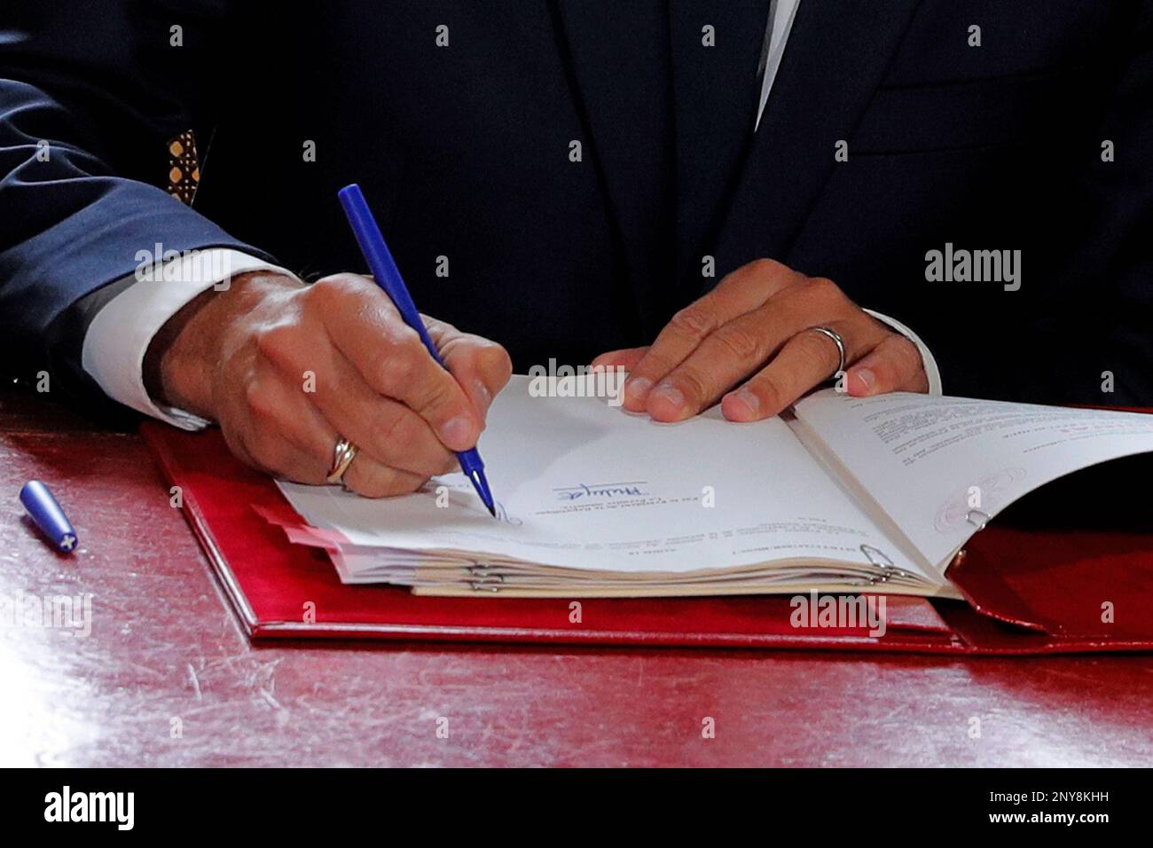 French President Emmanuel Macron signs documents in front of the media ...