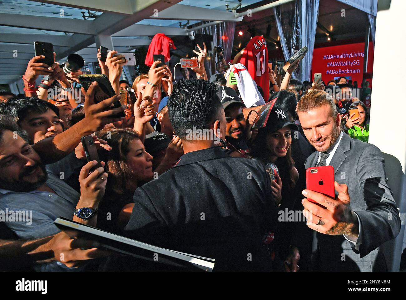 David Beckham taking photographs with fans after attending the AIA ...