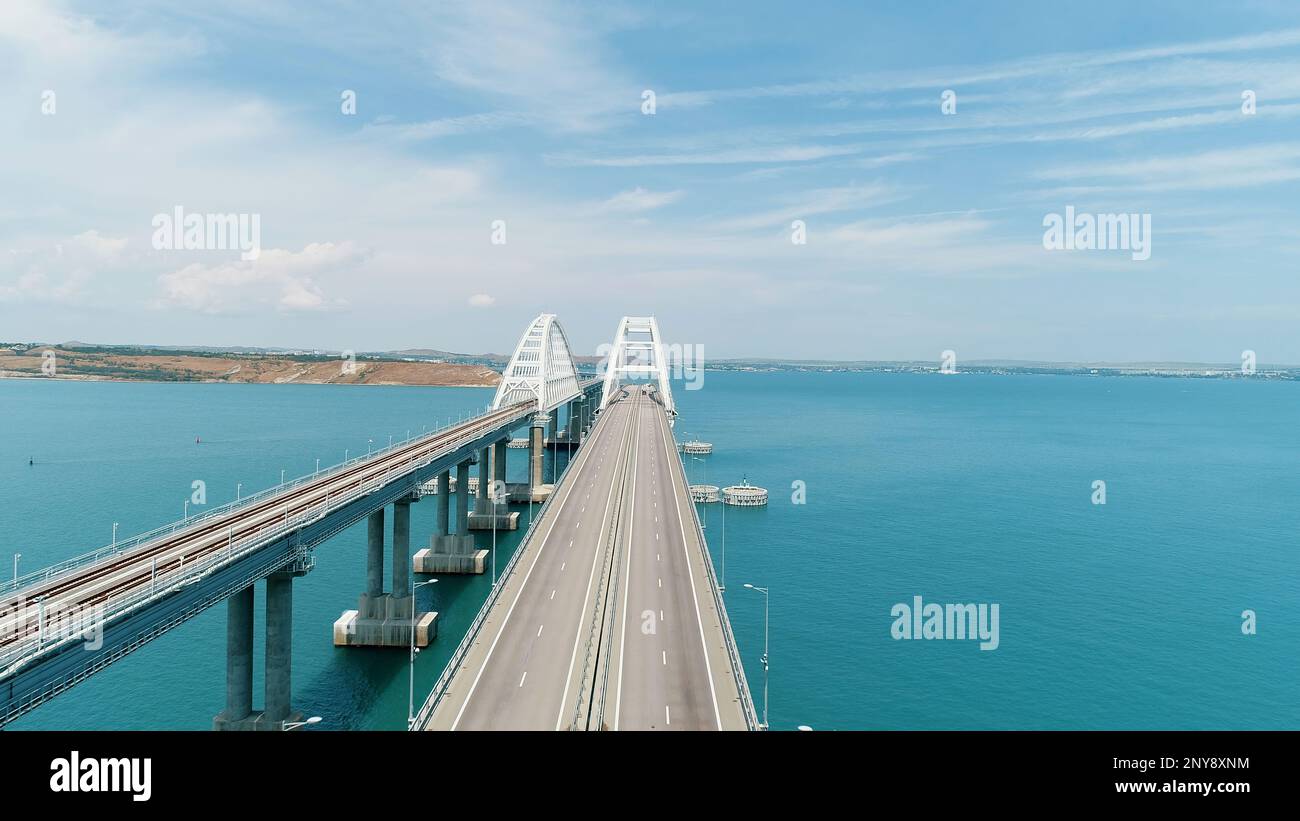 Aerial breathtaking view of the turquoise sea and a long white bridge ...
