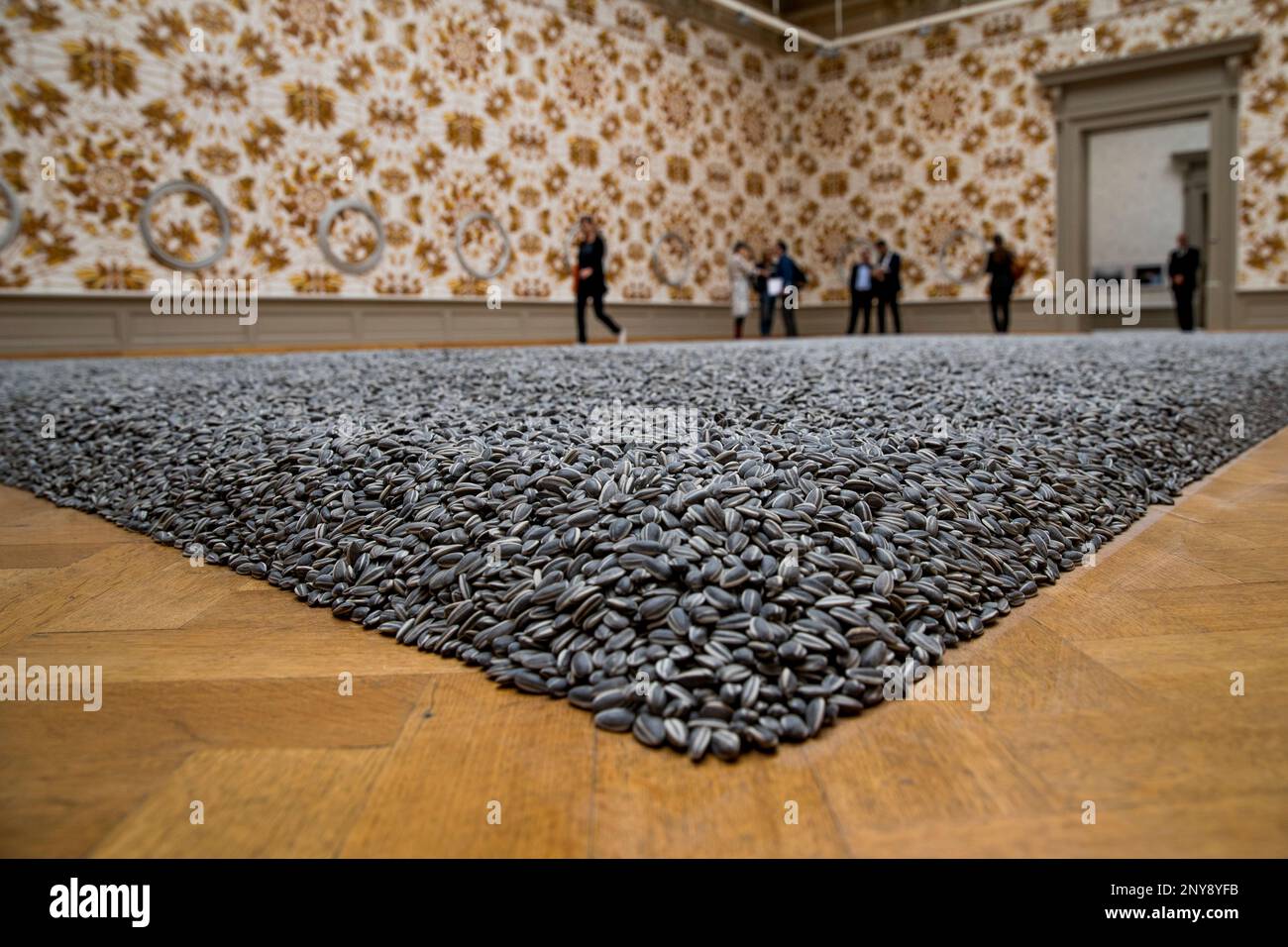 Visitors walk behind the installation 'Sunflowers Seeds' of Chinese ...