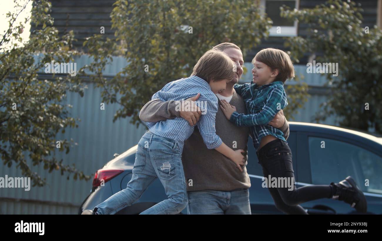 Father meets his little boys near his car outdoors. Stock. Concept of ...