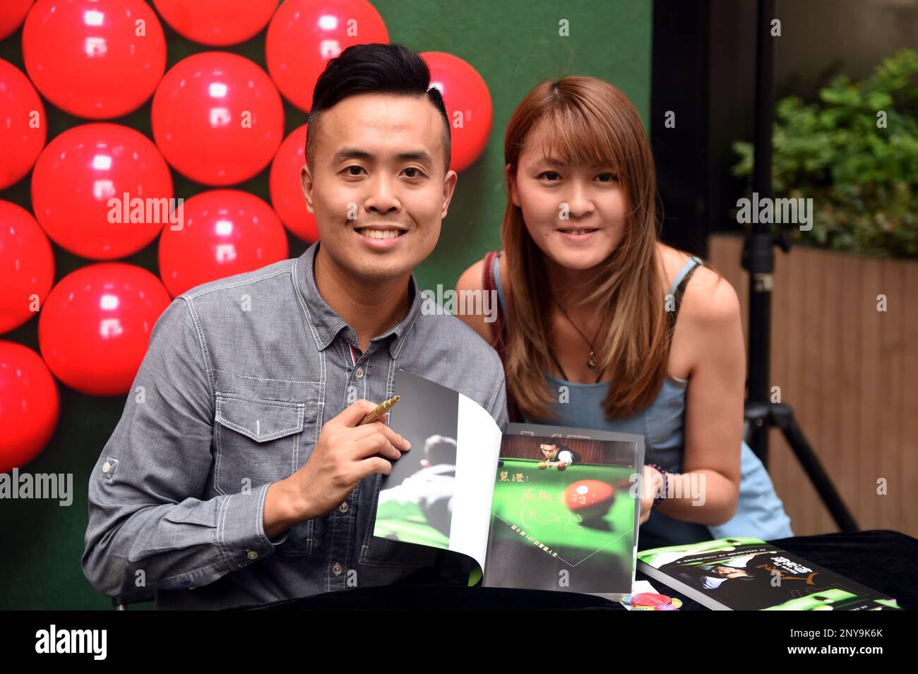 Hong Kong snooker player Marco Fu, left, poses with a fan during a ...